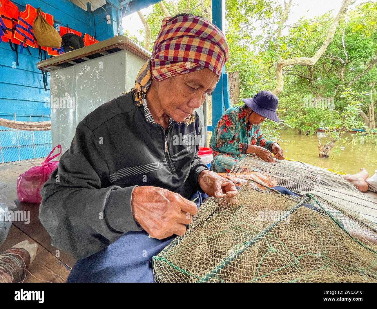 Cambodia, Kampong Phluk, fishing net repairer Stock Photo - Alamy