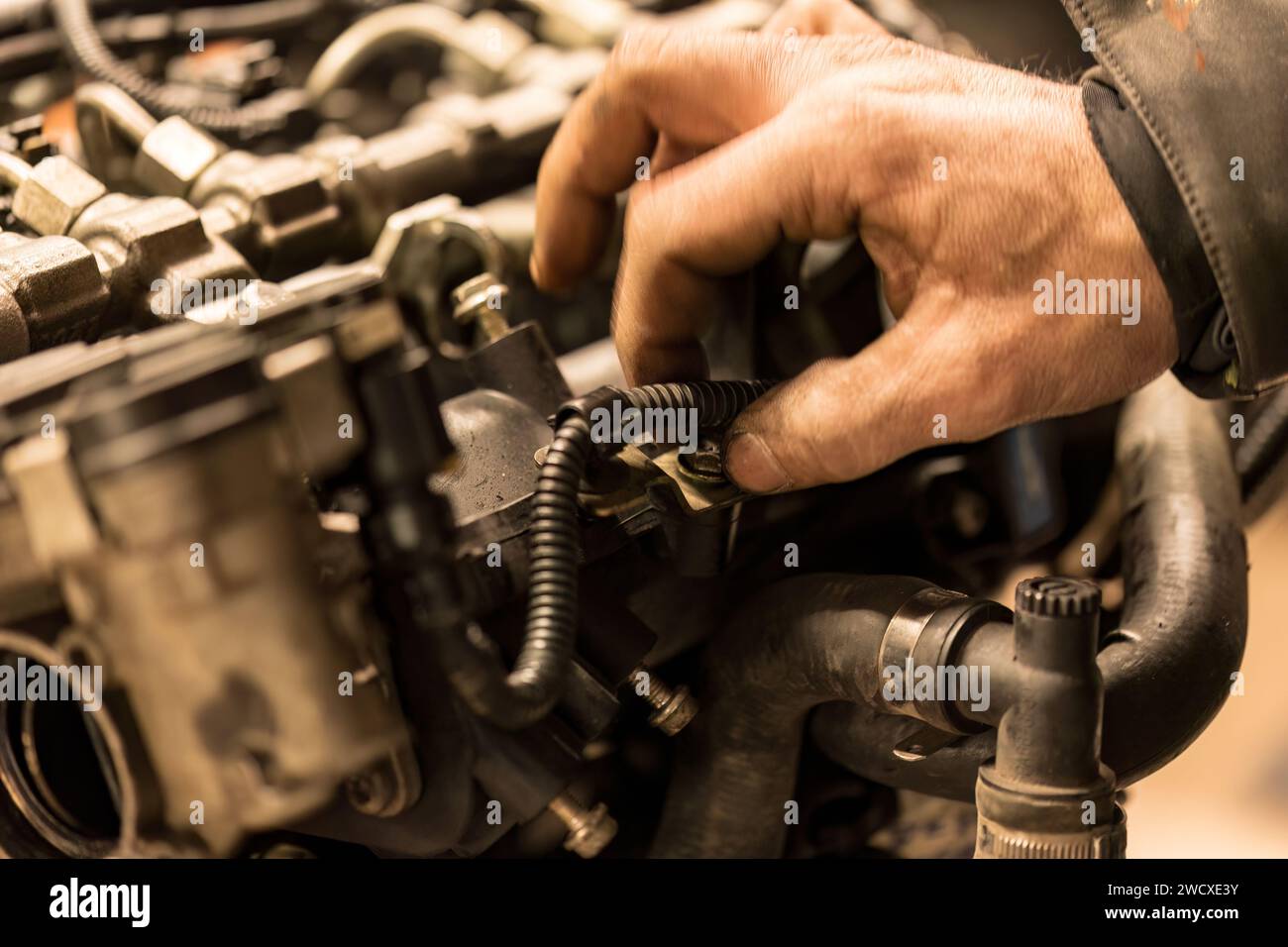 Photo capturing a mechanic's grimy hand on a car engine, highlighting ...