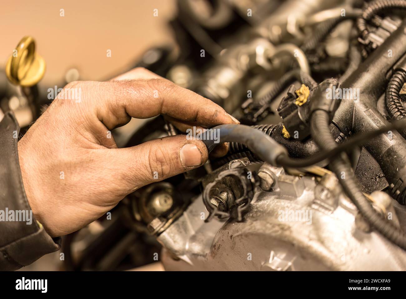 Photo capturing a mechanic's grimy hand on a car engine, highlighting ...