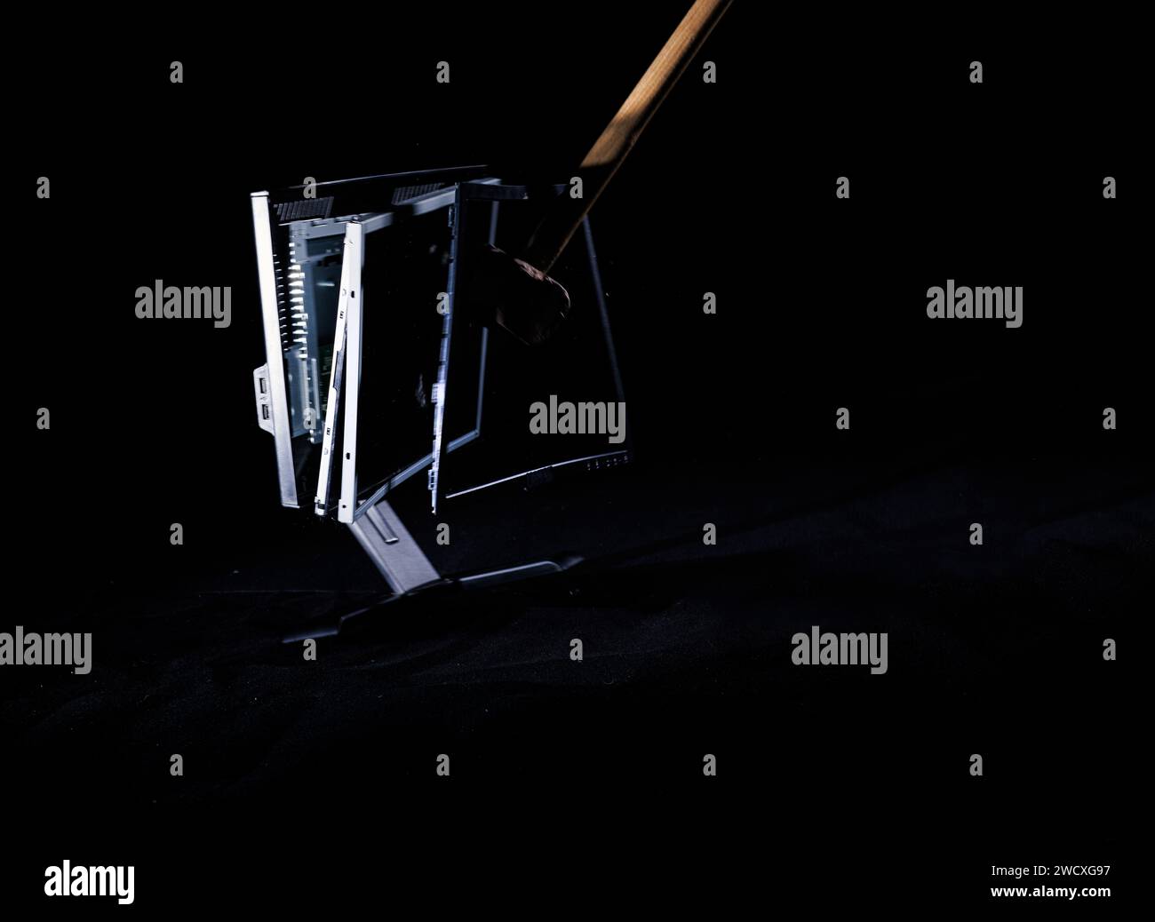 Blow of a big hammer to a computer monitor, isolated on a black ...