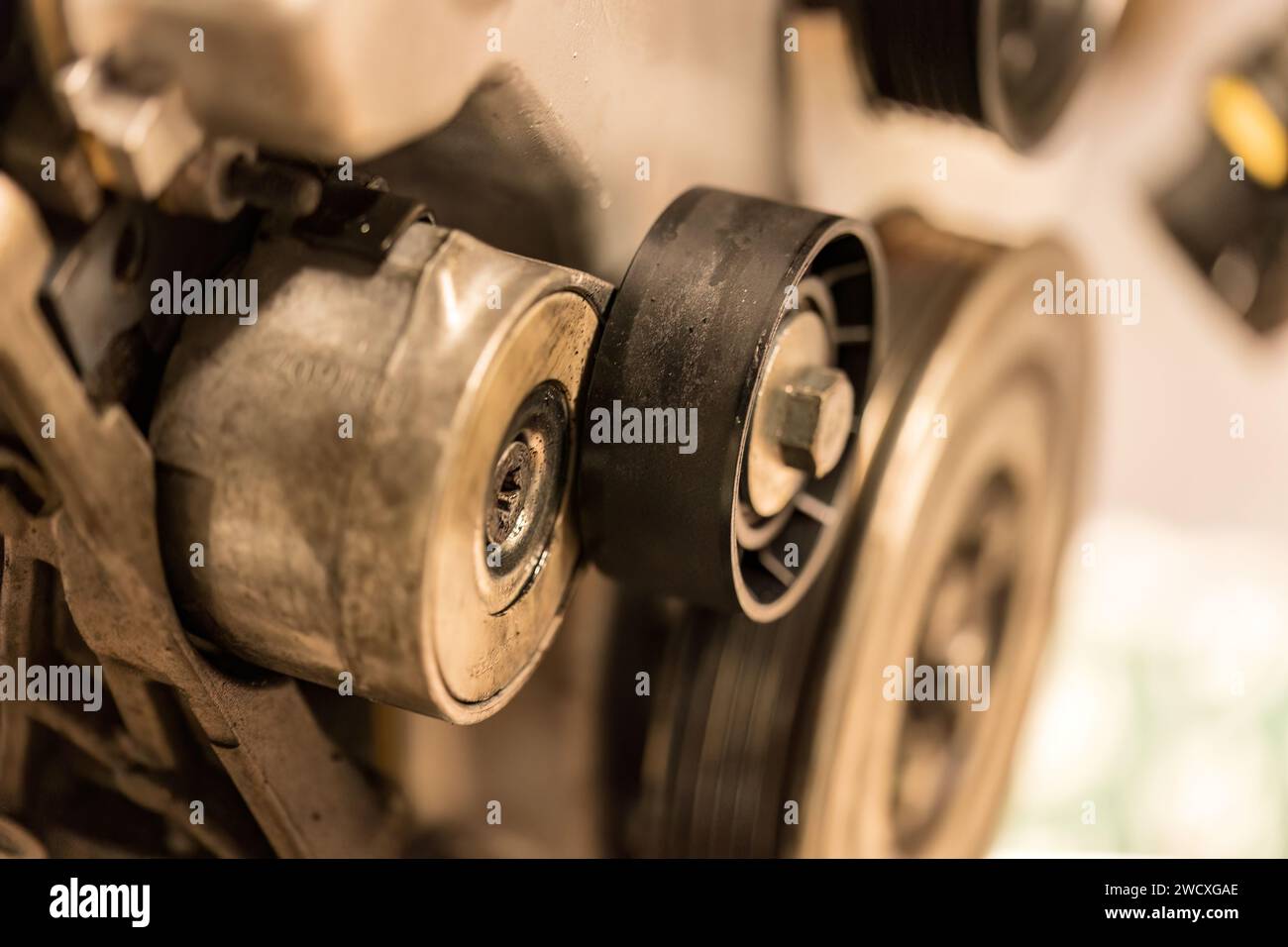 Photo focusing on the intricate pulleys of a car engine, highlighting ...