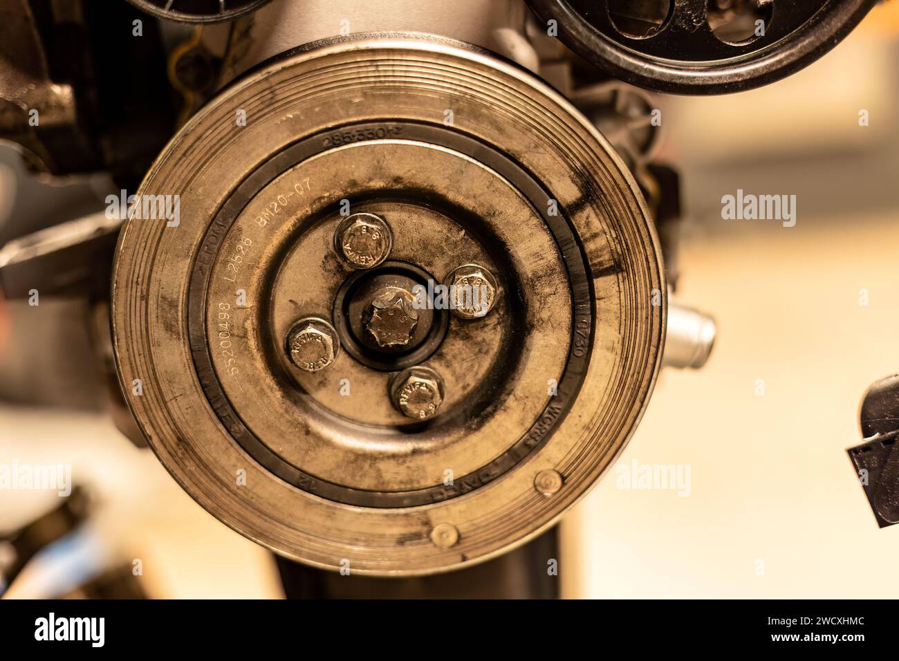 Photo focusing on the intricate pulleys of a car engine, highlighting ...