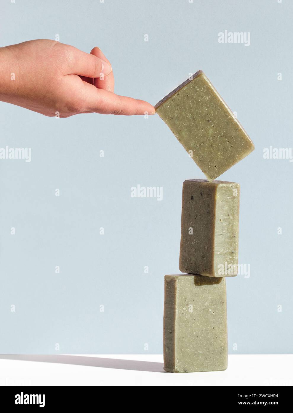 Woman's hand holding a falling bar of natural soap. Handmade cosmetics ...