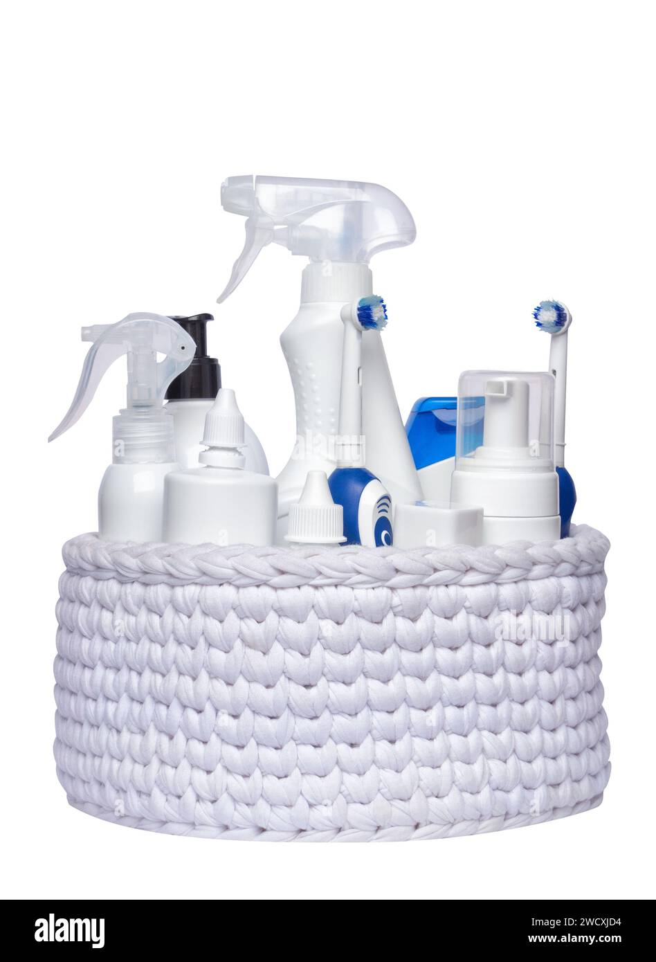Different plastic bottles and toothbrushes in a white knitted basket ...