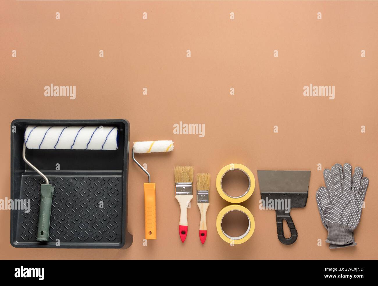 Set of tools for painting on a beige background. Rollers, brushes ...