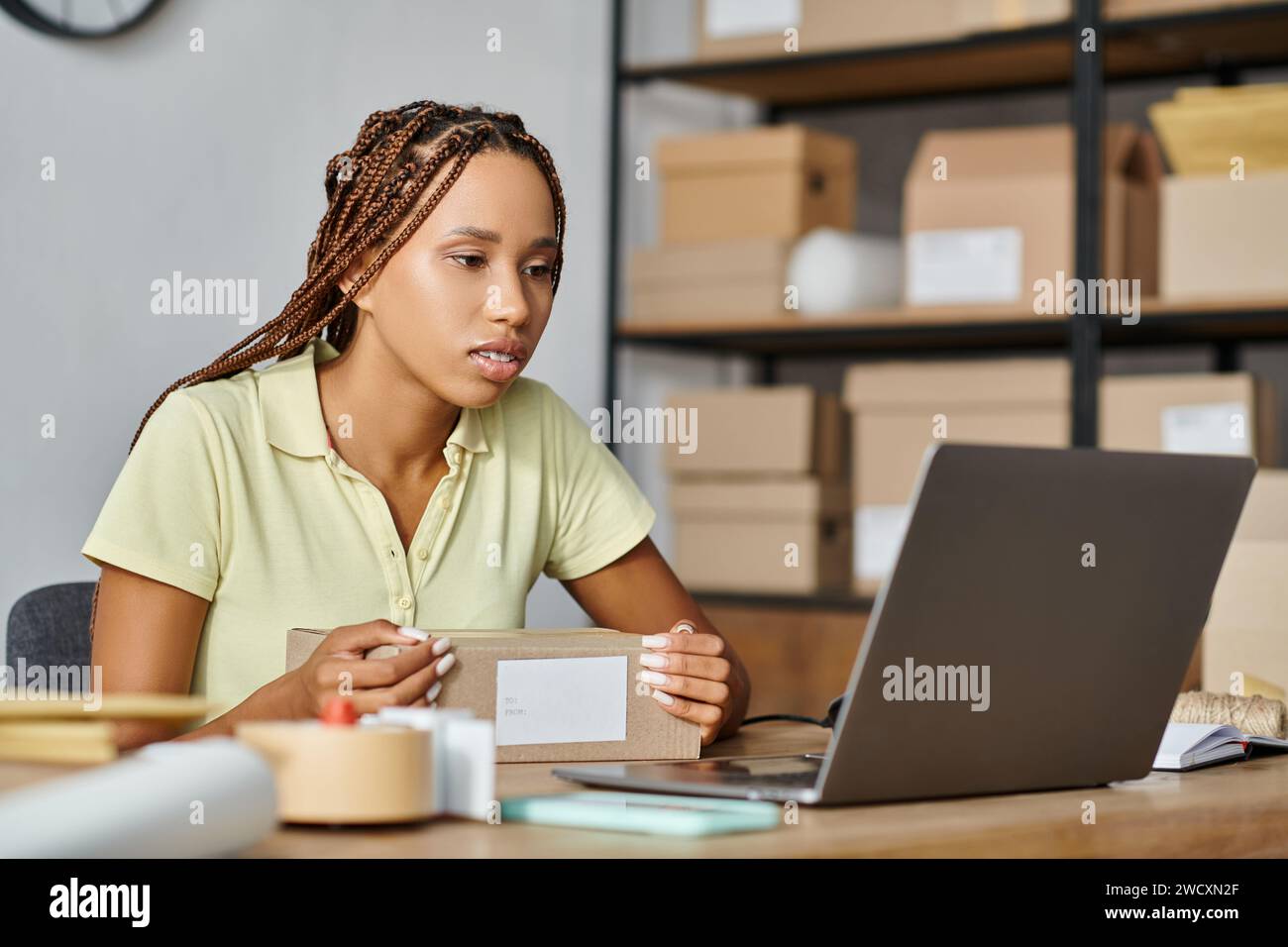 attractive african american female merchant looking at her laptop while ...