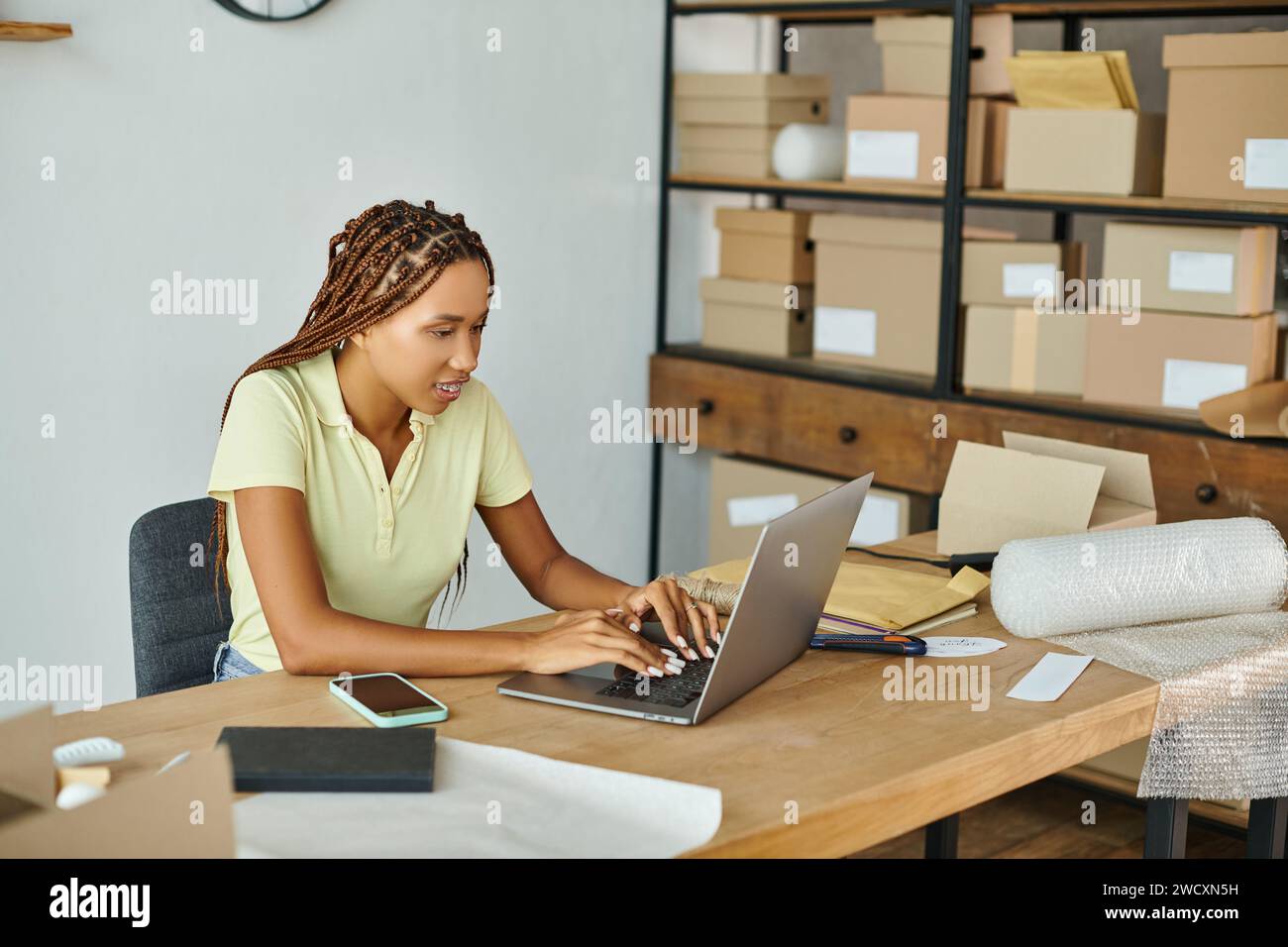 joyful african american seller in casual attire working hard on her ...