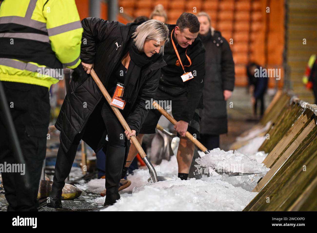 Blackpool club staff help to clear ice from around the pitch during the ...
