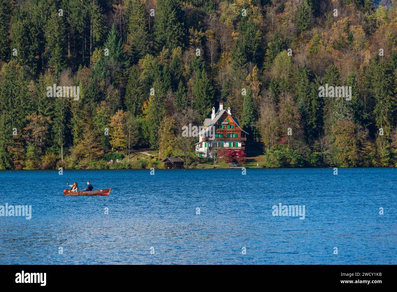 A scenic view of a tourist couple in a paddle boat on Lake Bled in ...