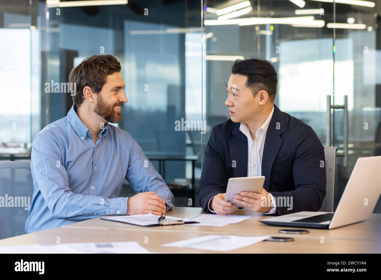 Two professional businessmen collaborating in a modern office setting ...