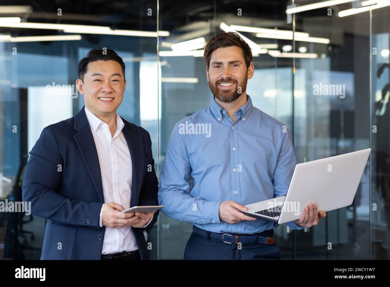 Two professional businessmen working together in a corporate office ...