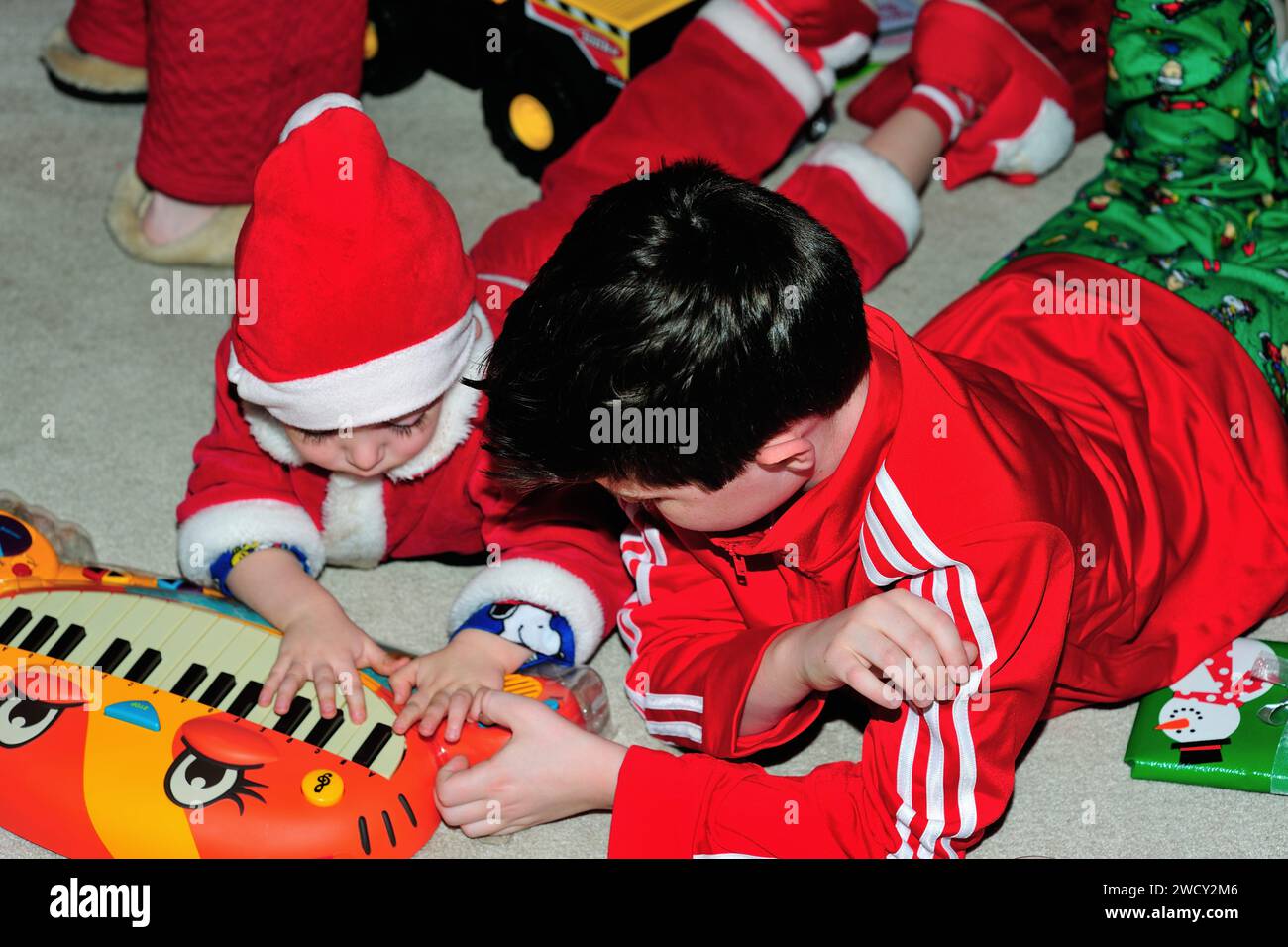 Sibling brothers one decked out in a Santa Claus suit, play with an ...