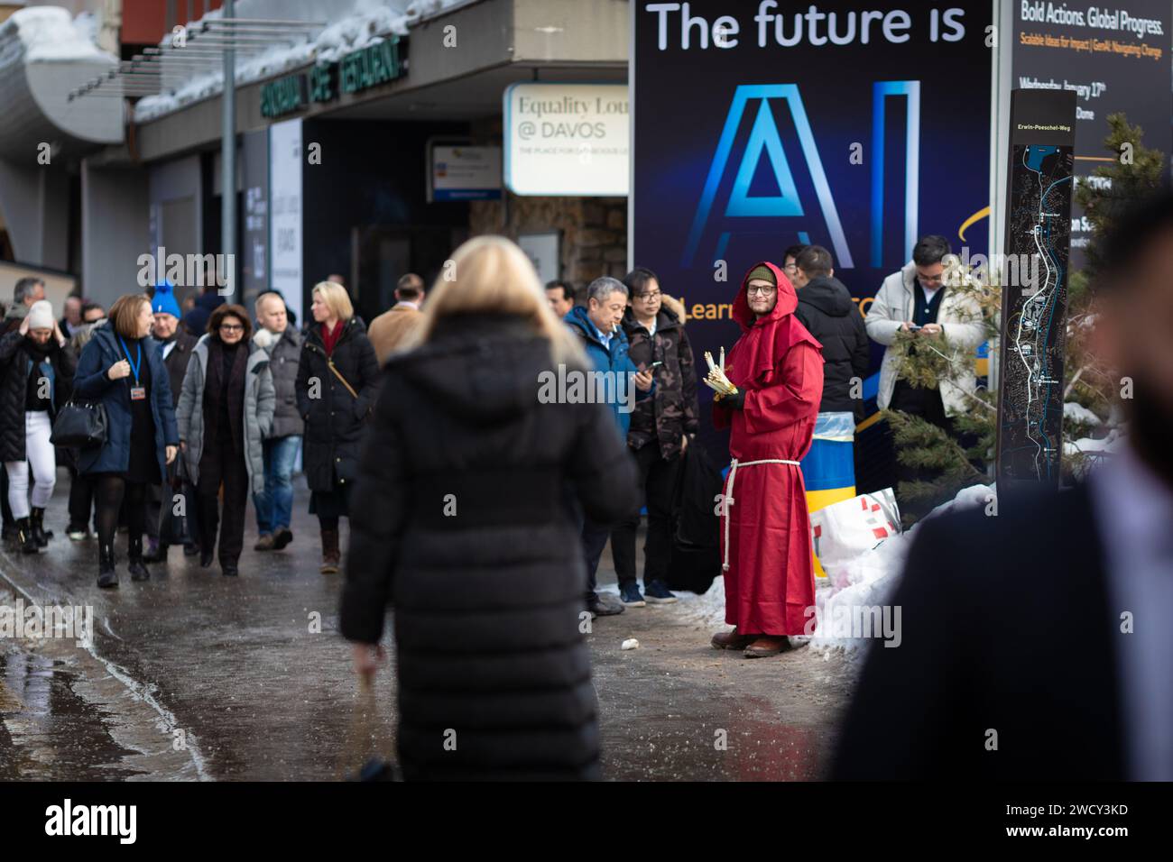 Davos, Switzerland. 17th Jan, 2024. People walk past a sign promoting ...
