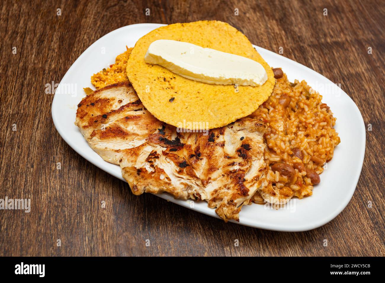 Grilled chicken, arepa, cheese, fried egg and reheated beans with rice ...