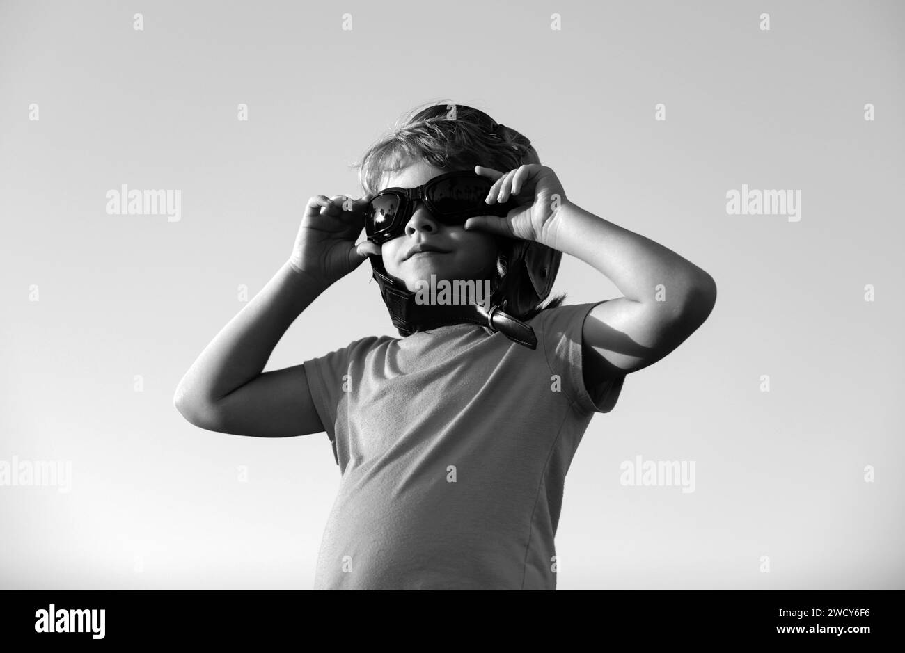 Child boy playing with pilot goggles and helmet, dream of becoming a ...
