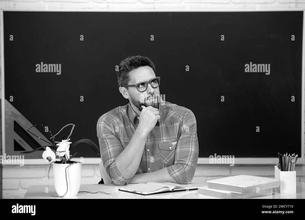 Portrait of confident caucasian male teacher in classroom. Young male ...