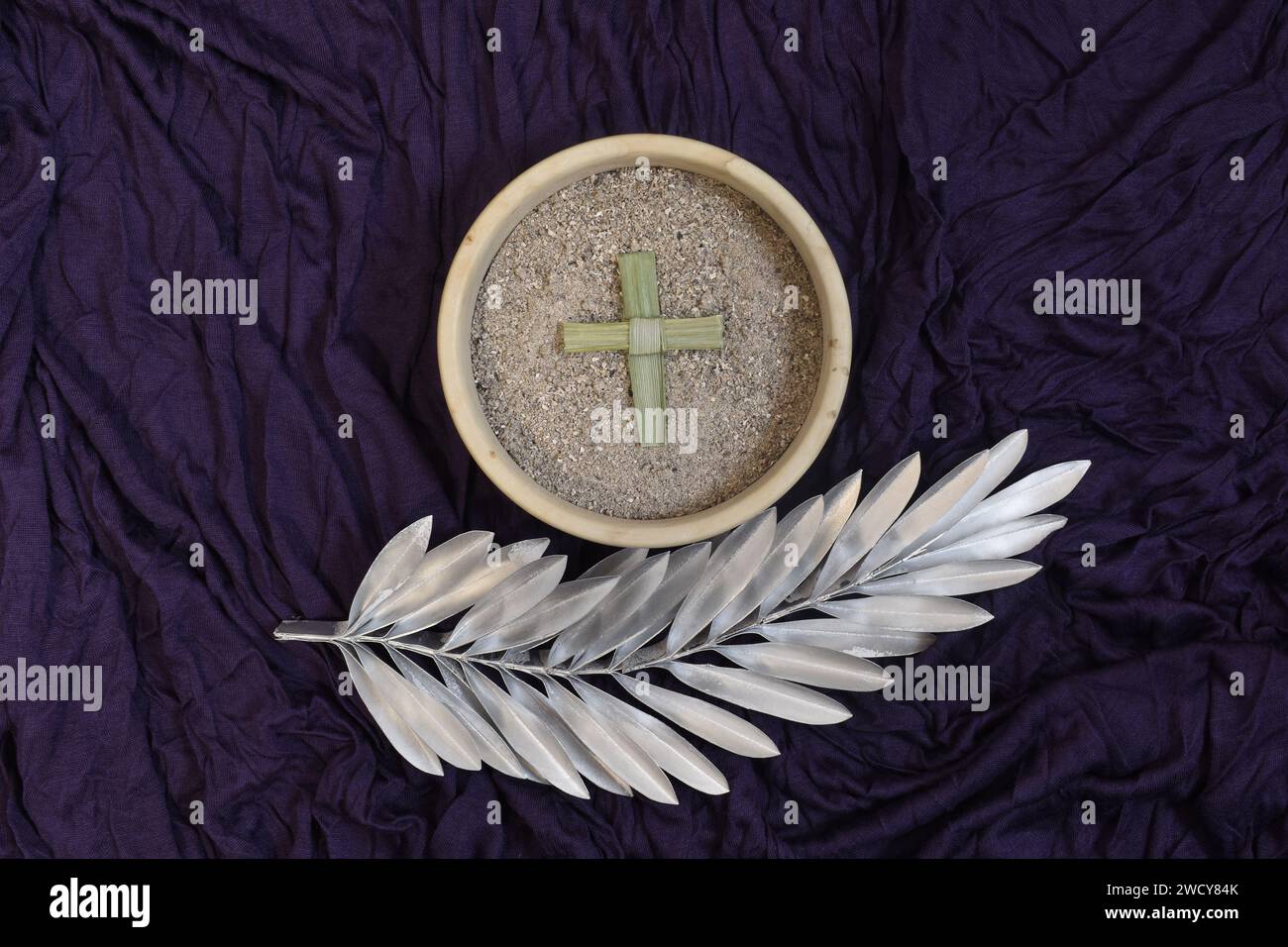 Ash, cross and silver palm leaf on purple background. Ash Wednesday ...