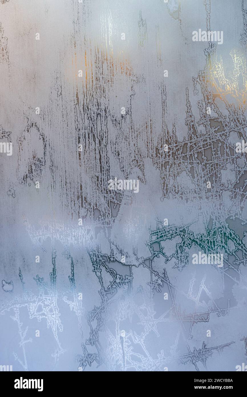 window glass covered with ice and frost. ice pattern on glass. vertical ...