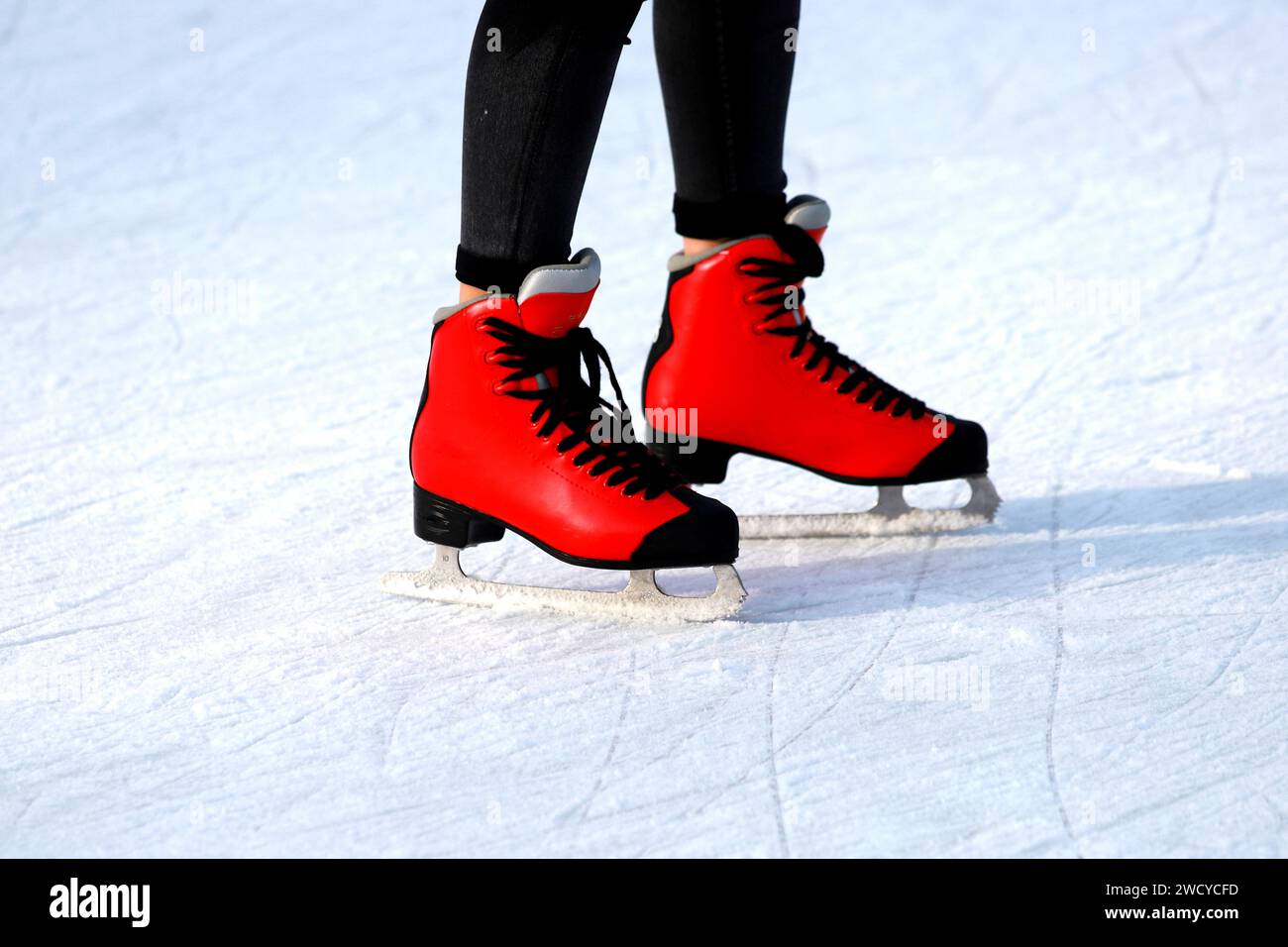 Winter skating rink. Red skates skate on the ice. Active family sport ...