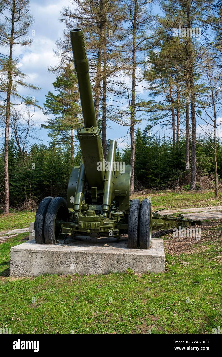 Green cannon from World War II. With four wheels on concrete base in ...