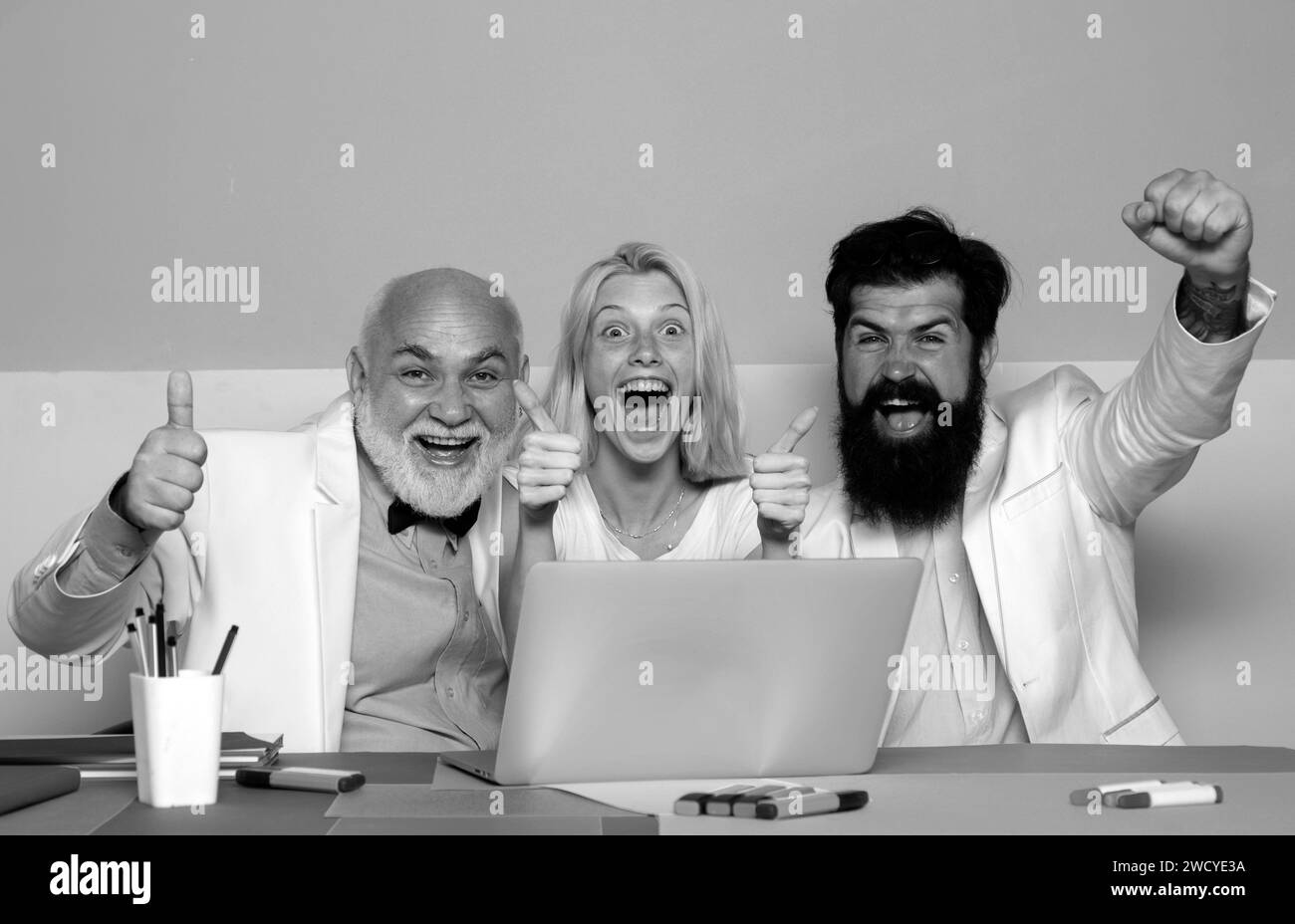 Excited business people sitting at the office table with group of ...