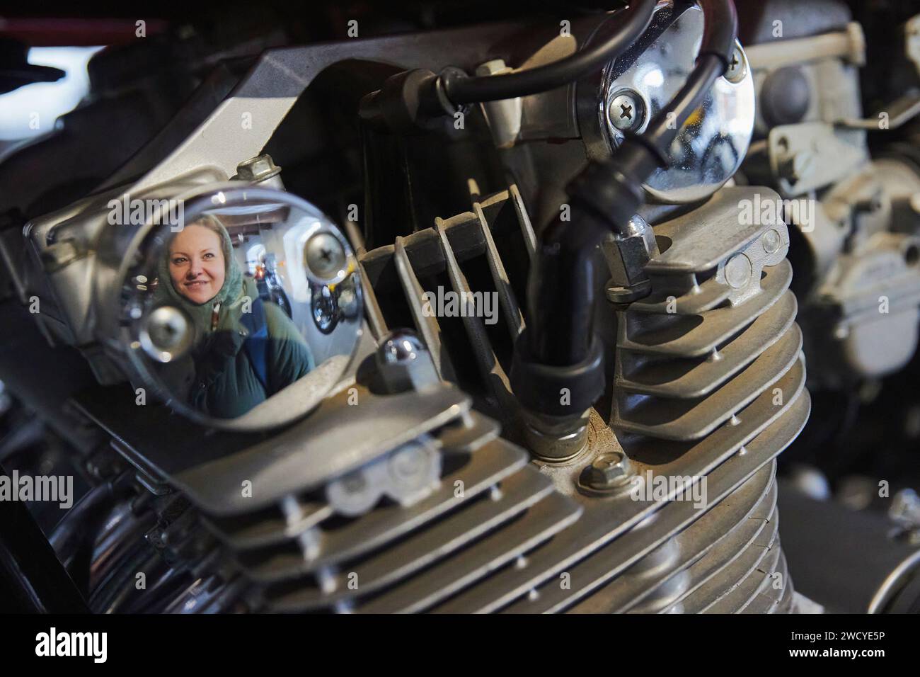 visitor is reflected in the engine of a vintage motorcycle in Denmark ...