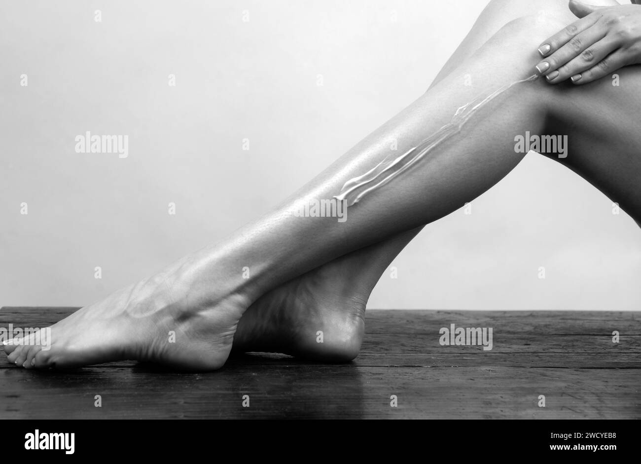 Woman applying moisturiser legs Black and White Stock Photos & Images ...