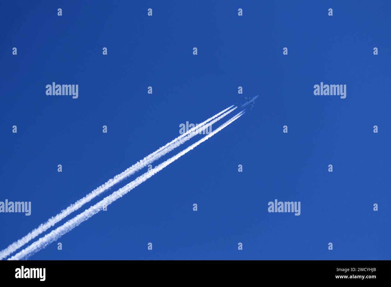 airplane trail in the clear blue sky Stock Photo - Alamy