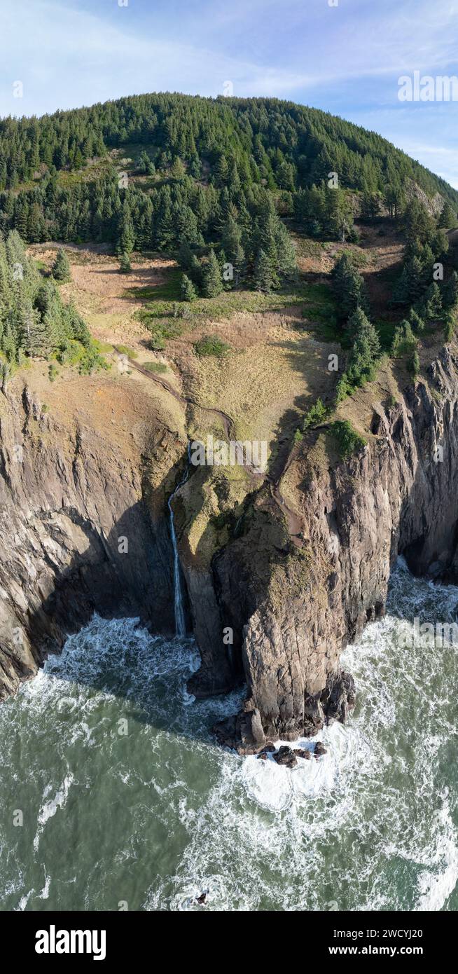A narrow waterfall tumbles off an impressive cliff near the Neahkahnie ...