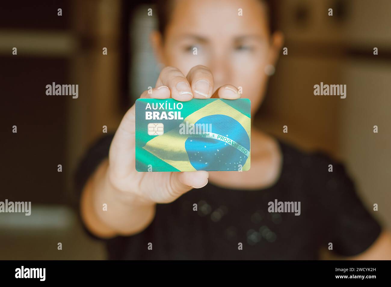 In this photo illustration a woman seen holding the Auxílio Brasil card ...