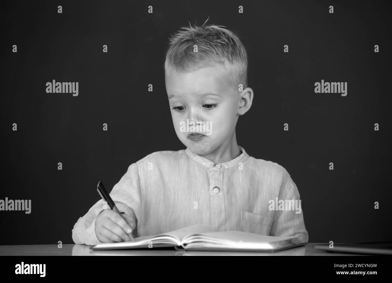 Kid writing in notebook in class. Back to school. School boy studying ...