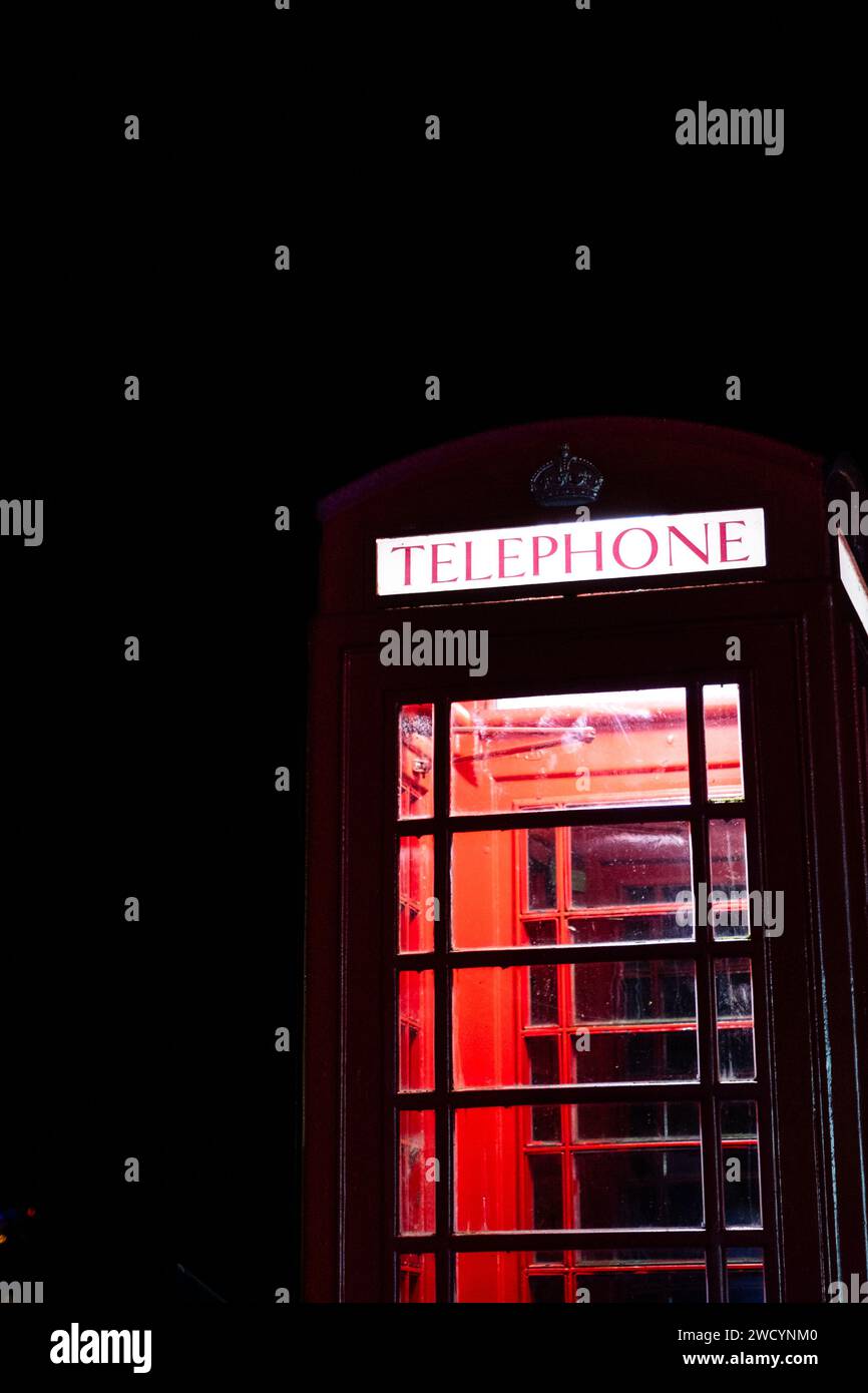 A vintage British red telephone box illuminated at night at Centre ...