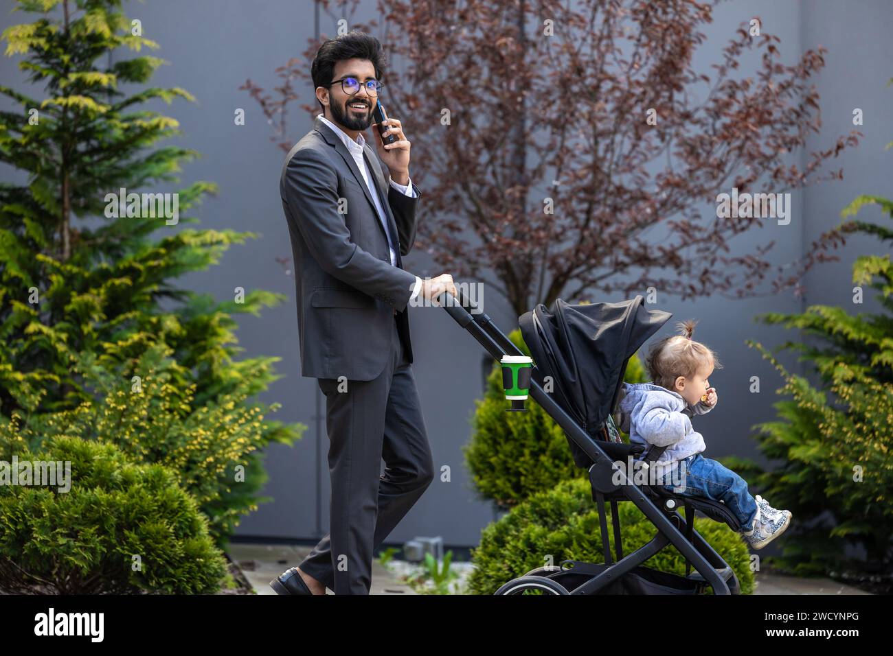 Young elegant man with baby carriage talking on the phone Stock Photo ...