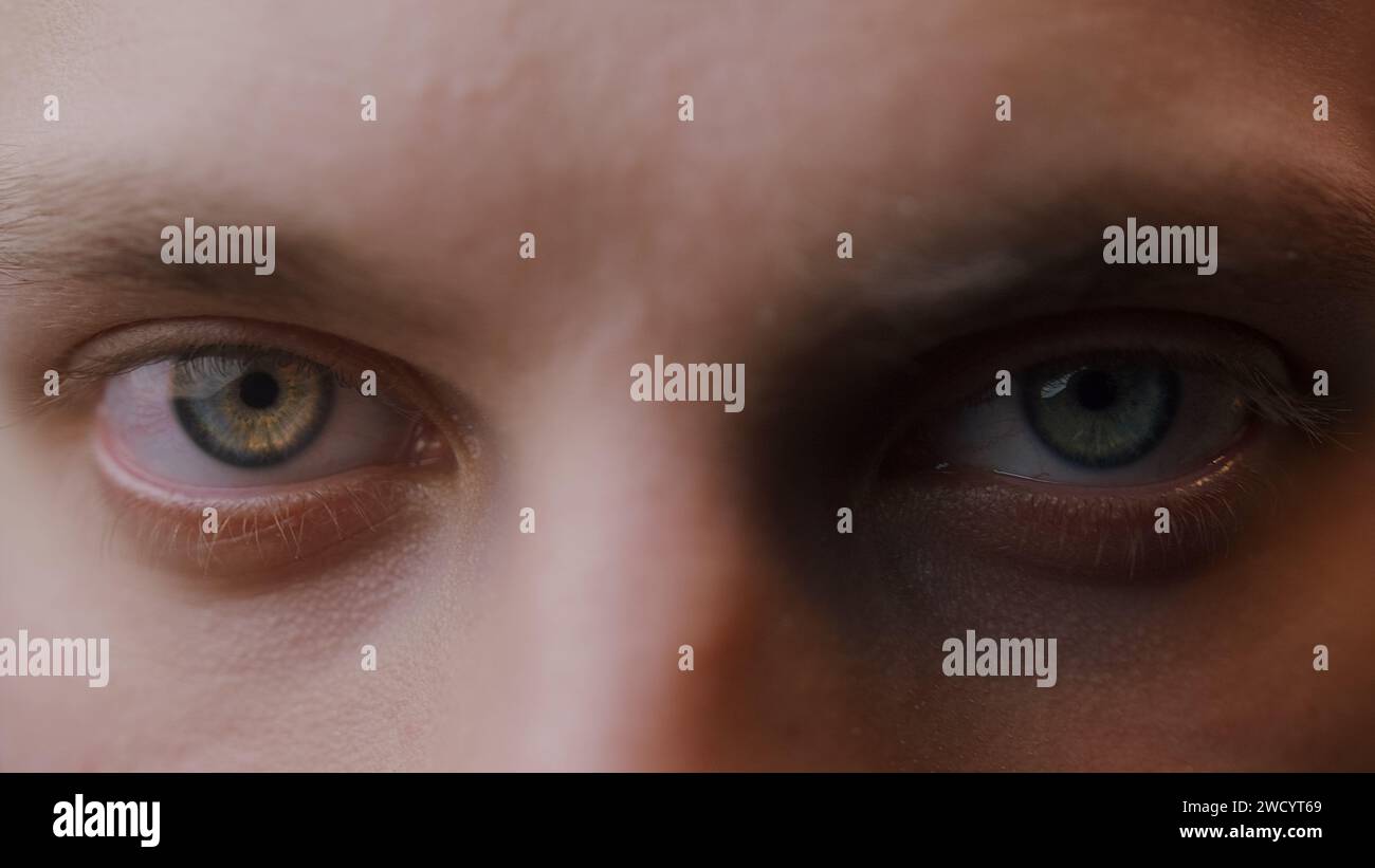 Extreme close-up colored eyes of young blonde man looking at camera ...