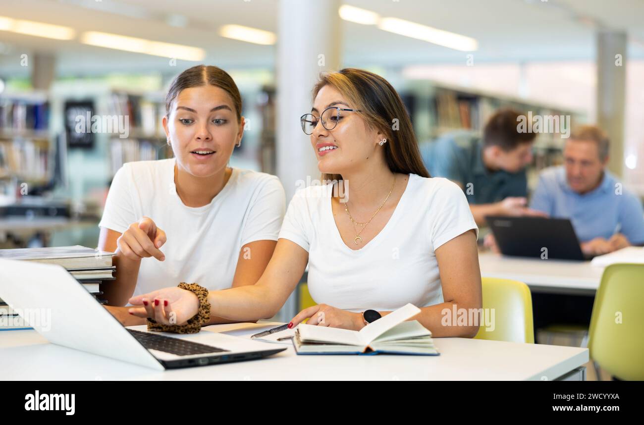 Student girls work together on project in the college library Stock ...