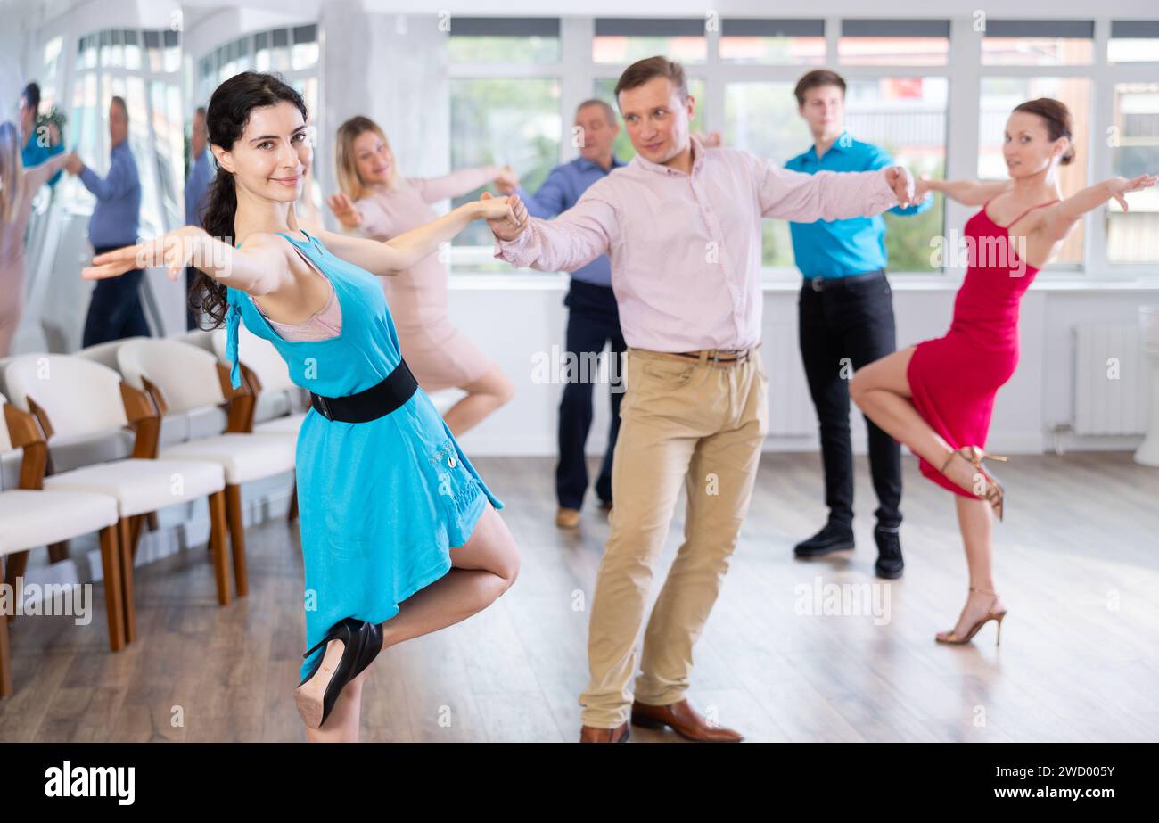 Positive pairs practicing vigorous jive movements in dance class Stock Photo - Alamy