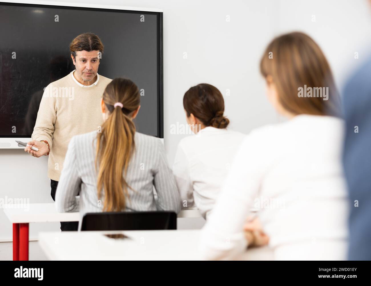 Experienced male teacher giving lecture to group of student Stock Photo ...