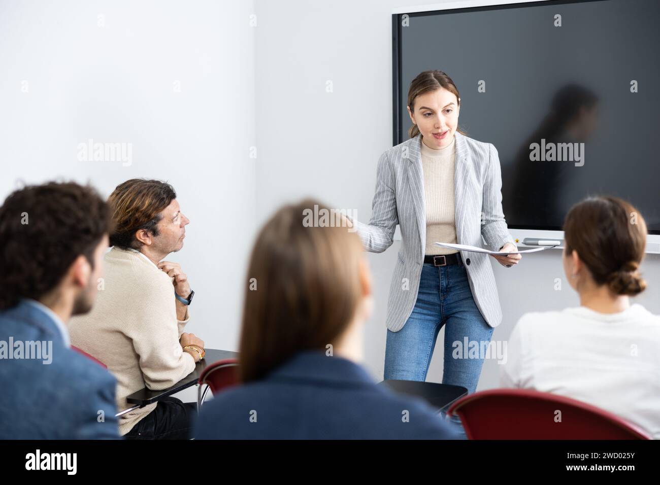 Young female teacher giving lecture to group of student Stock Photo - Alamy