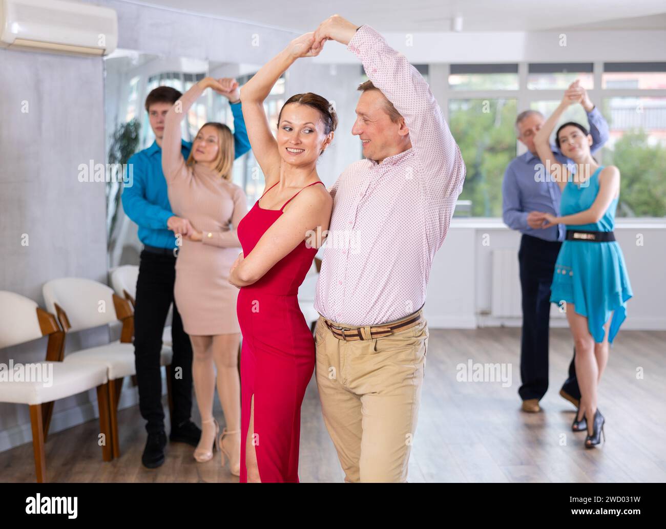 Group of different ages active people in festive clothes dancing dance ...
