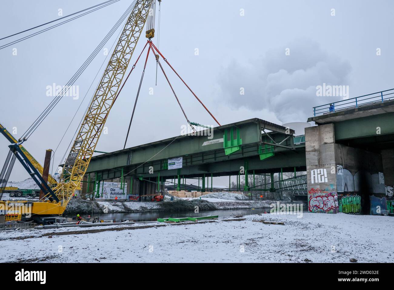Zwei große Spezialkräne heben die 320 Tonnen schwere Brücke aus ihrer ...