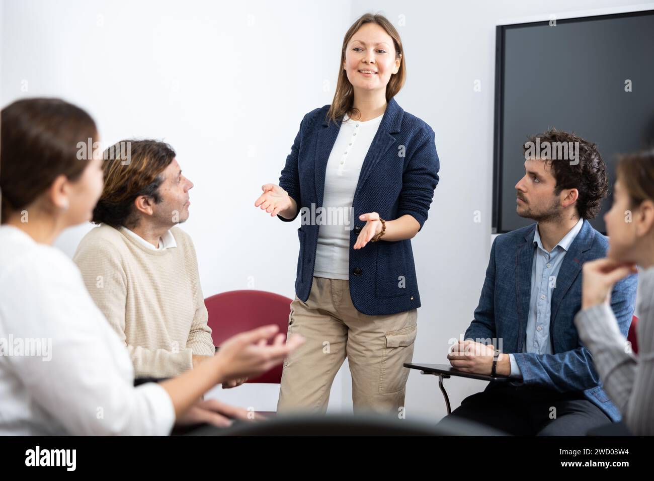 Experienced female teacher giving lecture to group of student Stock ...