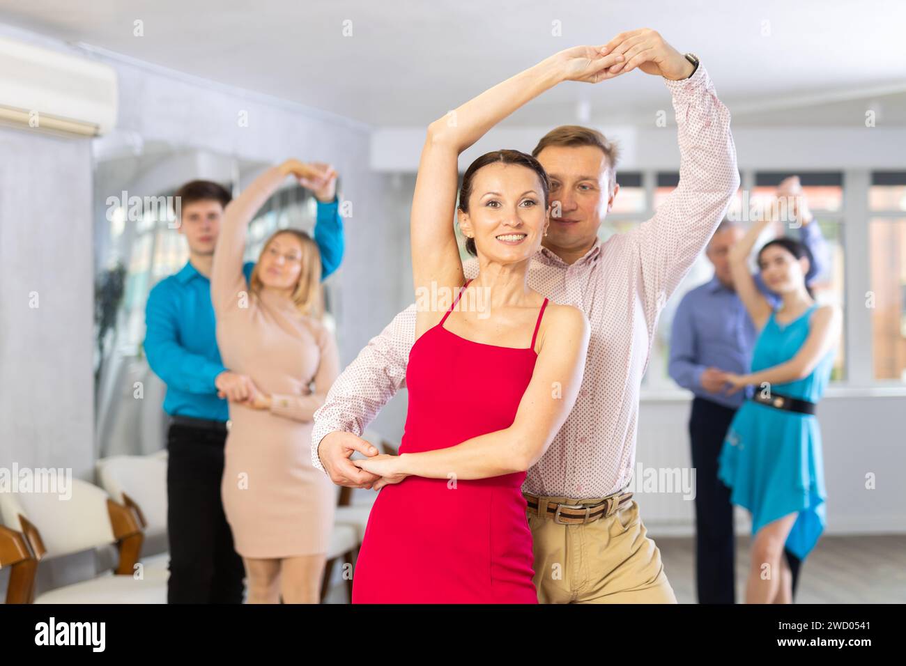 Group of different ages active people in festive clothes dancing dance ...