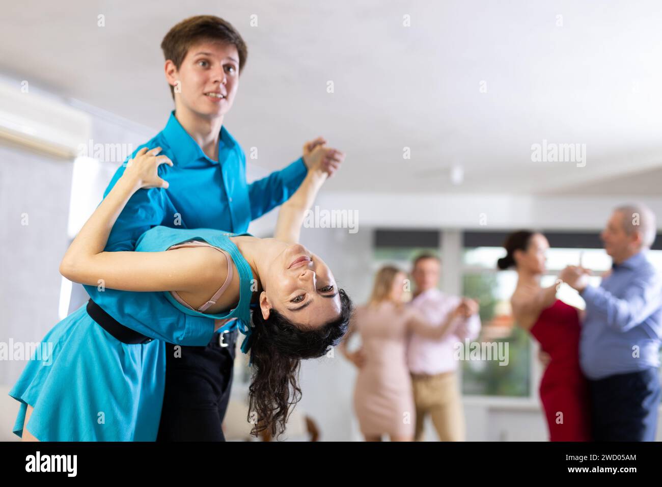 Teaching latin american dances in dance studio - people of different ages dance in pairs Stock ...