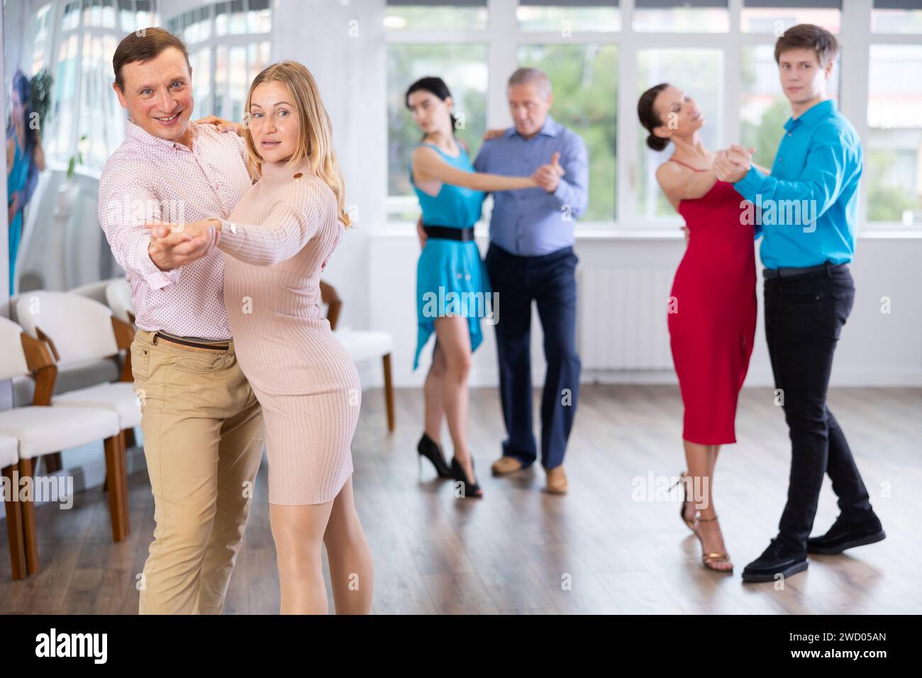 Positive adult couple enjoying slow foxtrot in dance studio Stock Photo ...