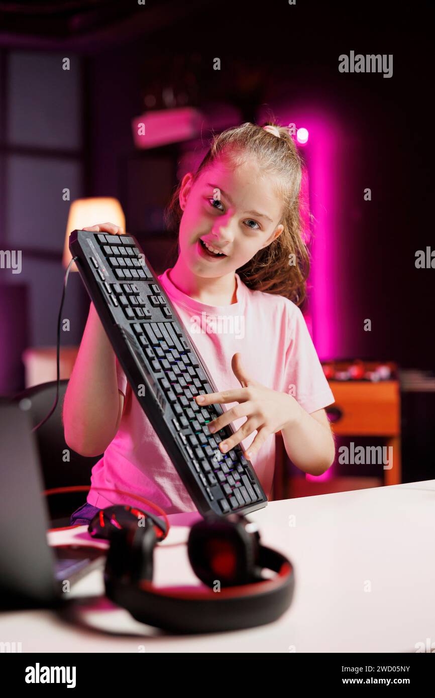 Cute girl reviewing mechanical keyboard received from sponsoring brand ...