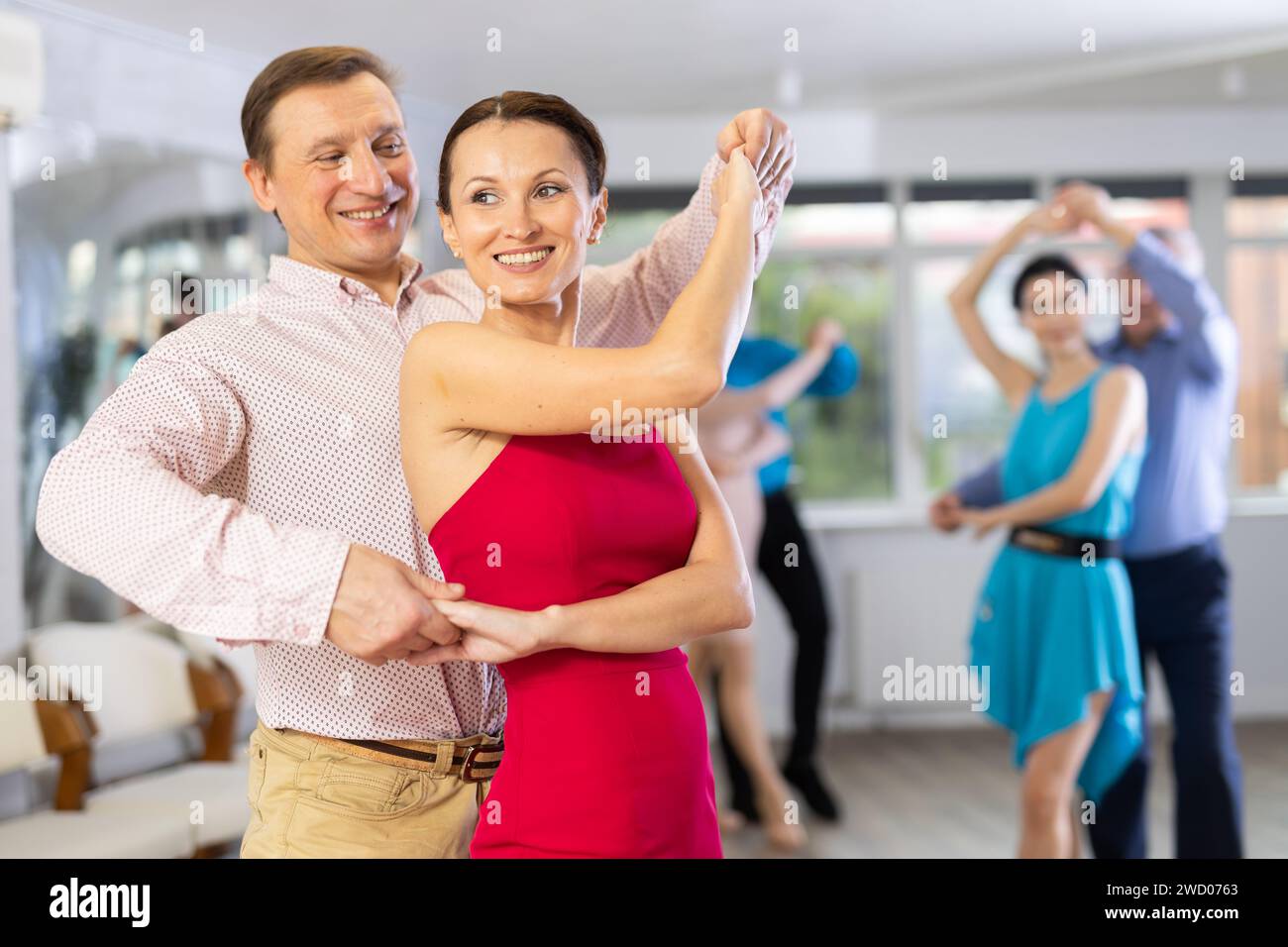 Group of different ages active people in festive clothes dancing dance ...
