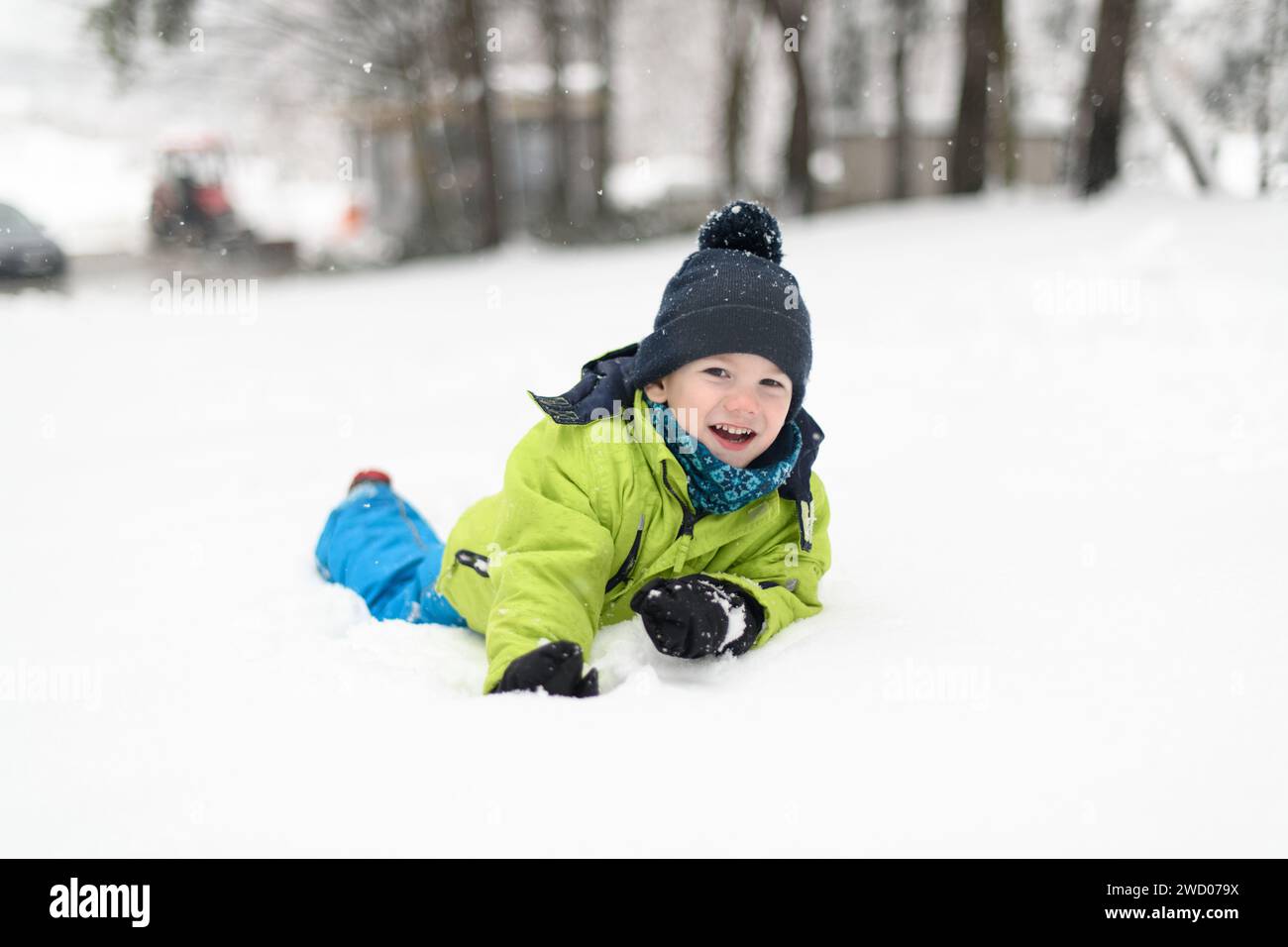 Little Boy Playing in the Snow Outside During a Snowfall Stock Photo ...