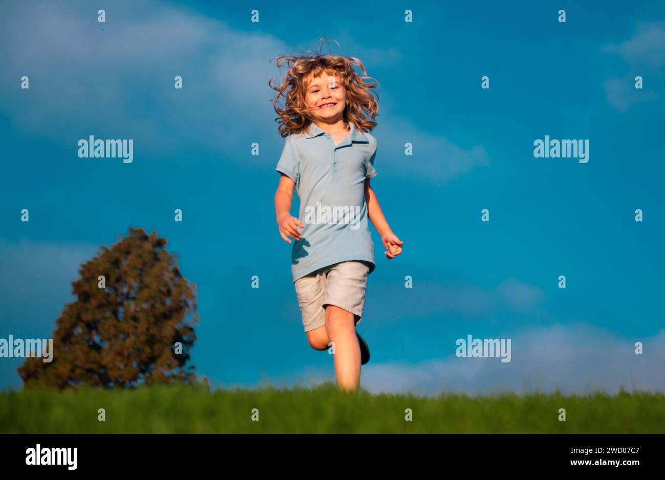 Child run in park outdoor. Spring kid walk on grass. Summer boy ...
