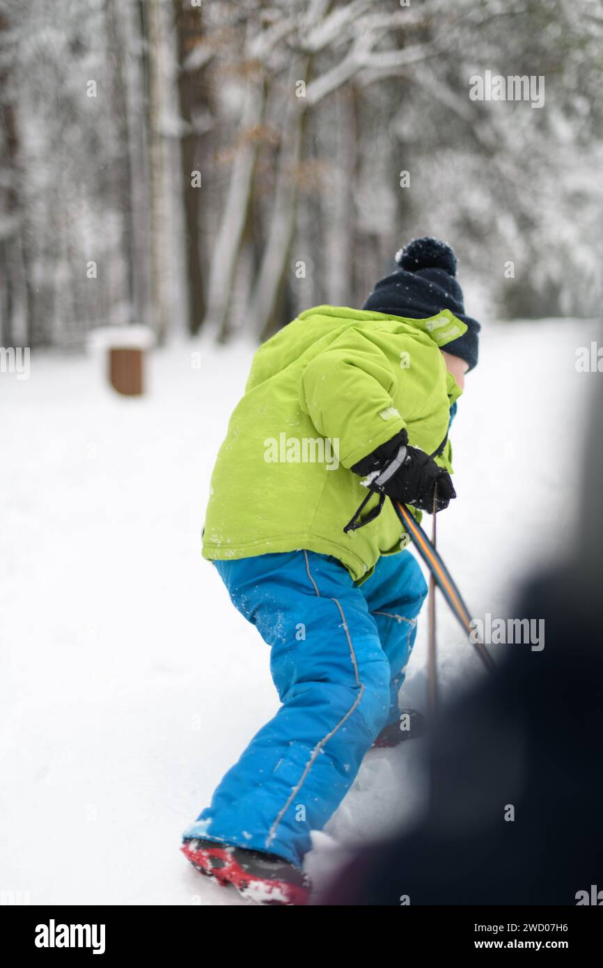 Little Boy Pulling a Sled in the Snow Outside During a Snowfall Stock ...