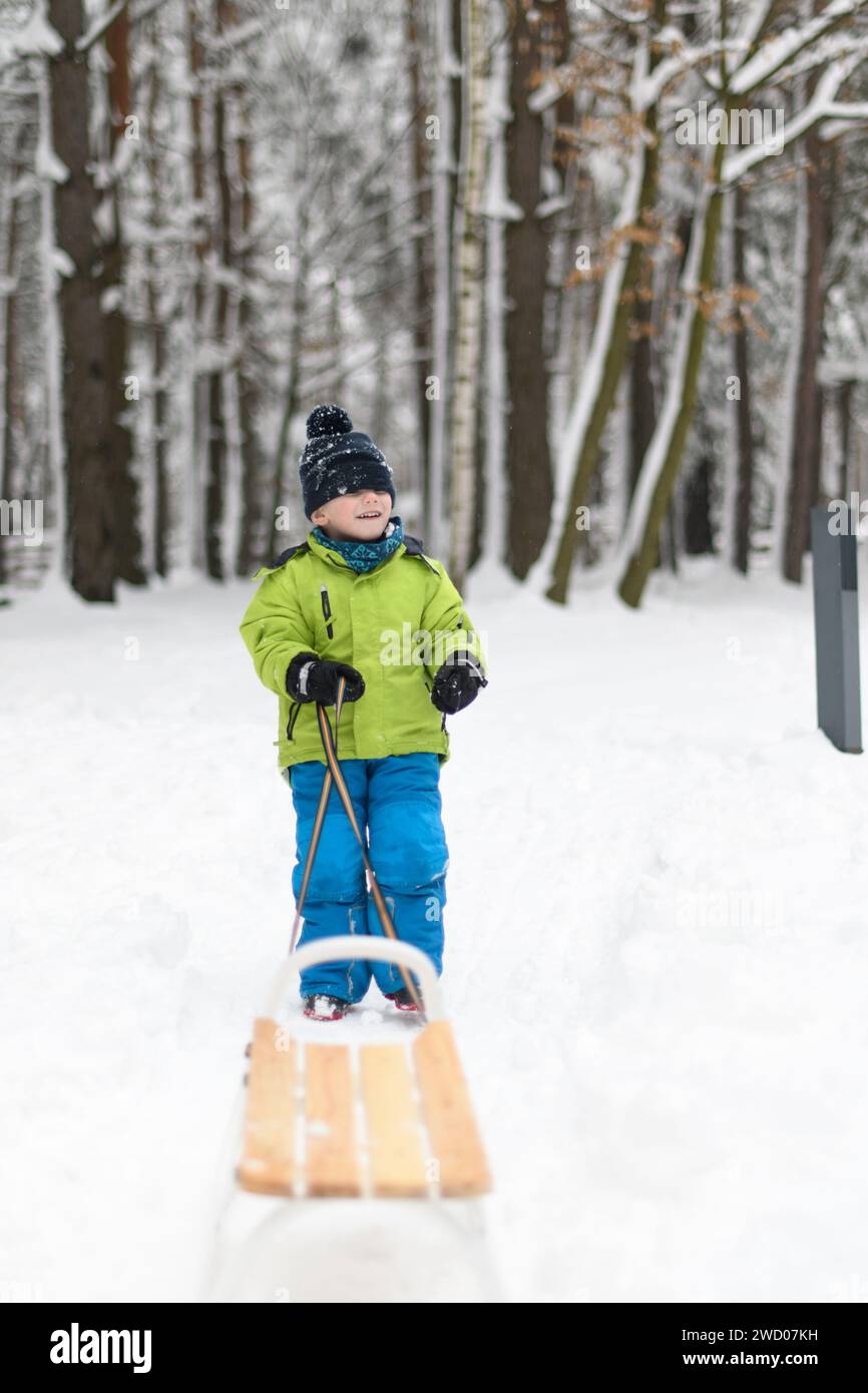 Boy Playing in Snow Pulling a Sled in the Woods While on Vacation Stock ...